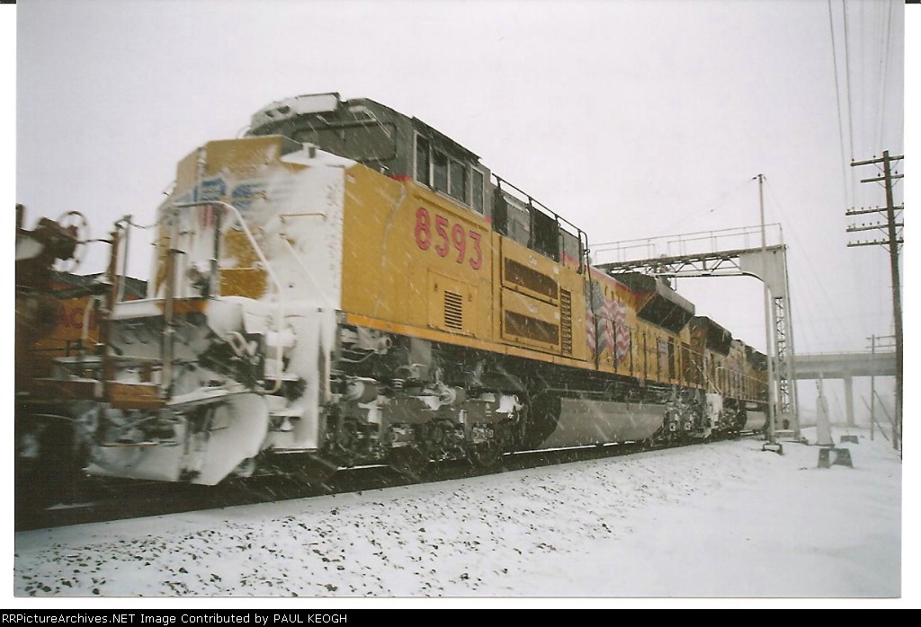 UP 8593 with UP 5090 as leader with a cow catcher full of snow passes me in a snow storm.